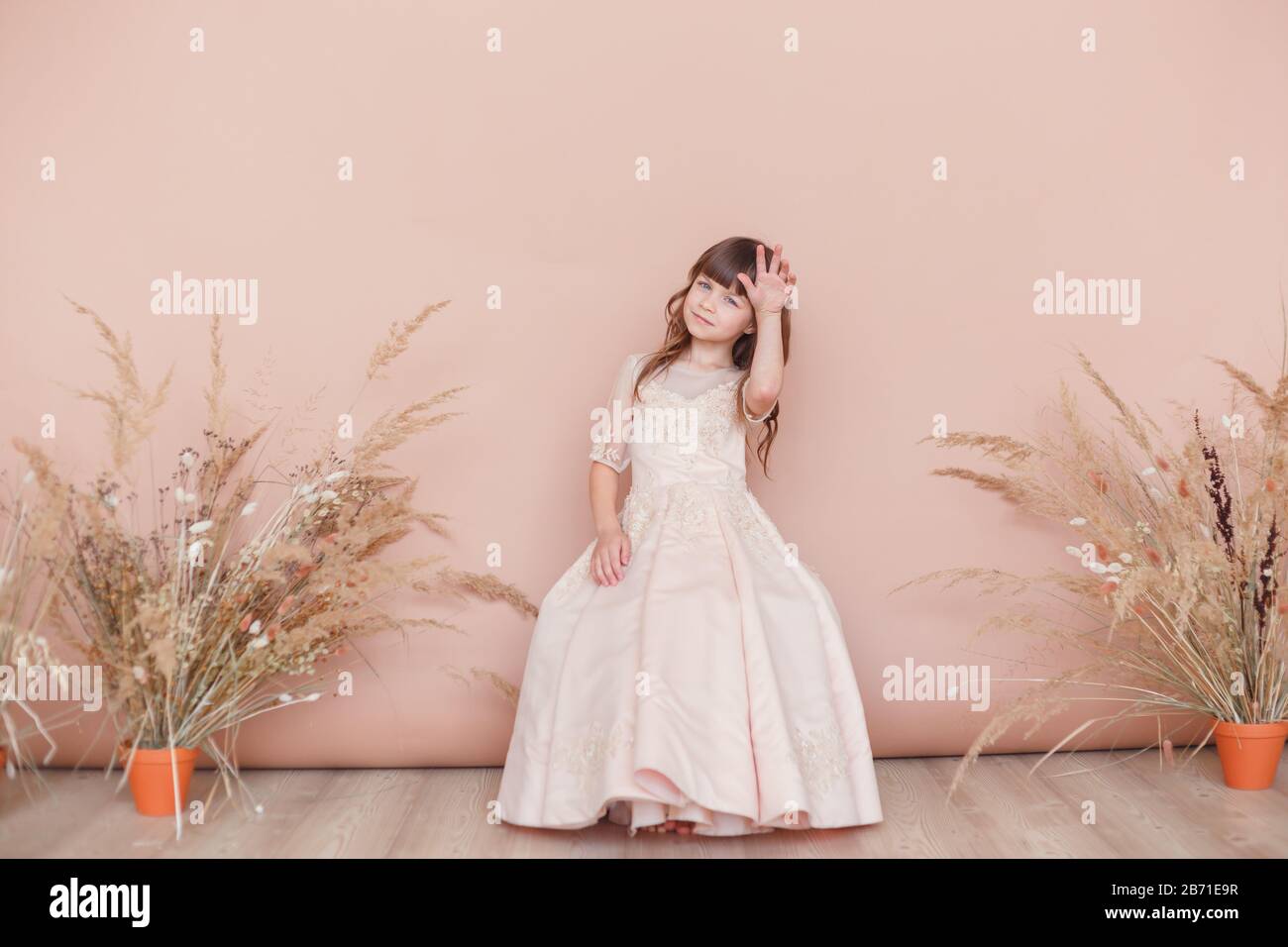 Young model girl in beige dress posing on pastel color background Stock ...