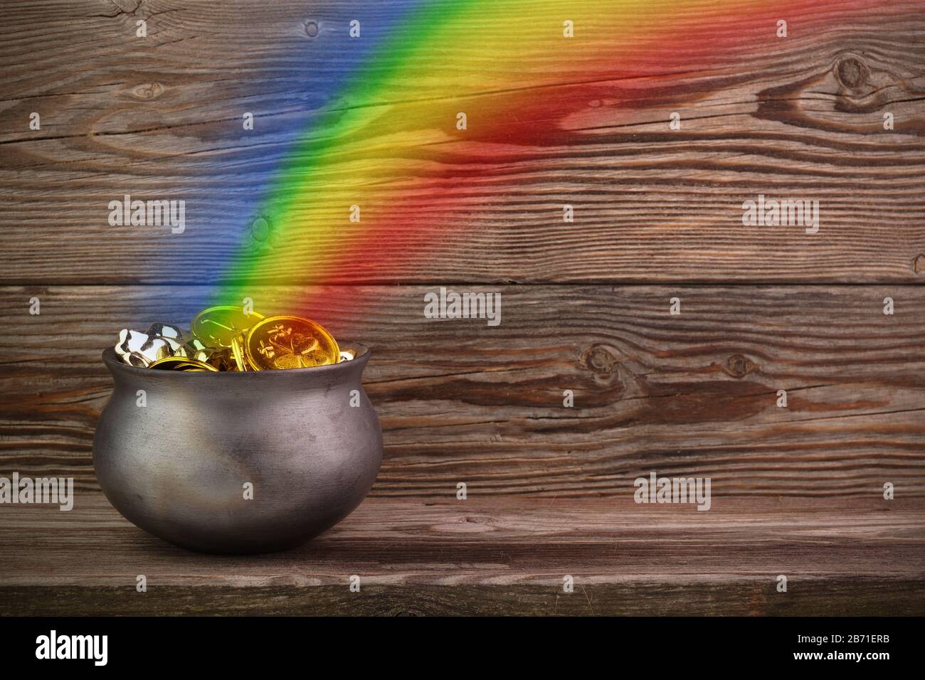 Rainbow pot of gold on old wooden background. St. Patrick's day symbol ...