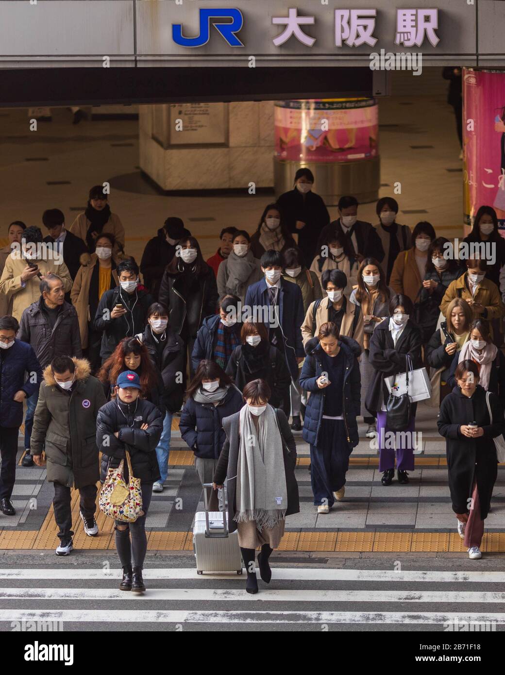 Osaka, Japan - March 4, 2020: A small crowd of mostly masked ...