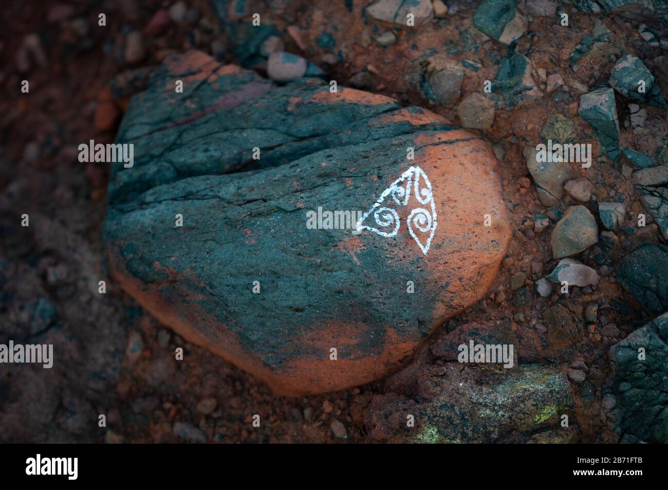 Painted boulder on the beach at Piha, on New Zealand's north island ...