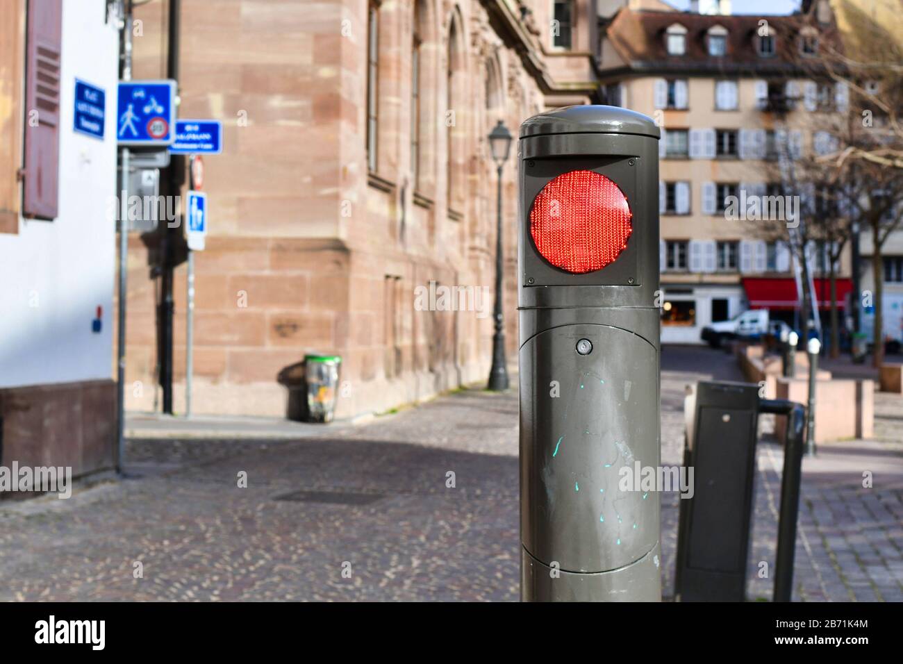 Retractable bollard with red light blocking way towards historical city ...