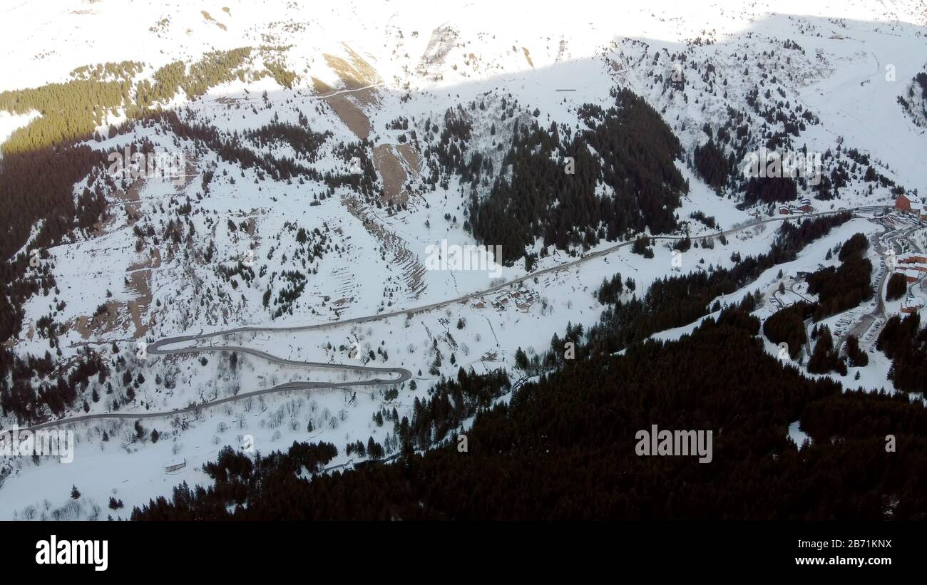 Aerial winter scene of alpine snowy mountain peaks and dark spruce ...