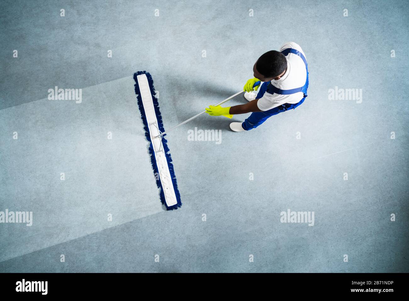 Man With Mop And Wet Floor Sign Stock Photo - Alamy
