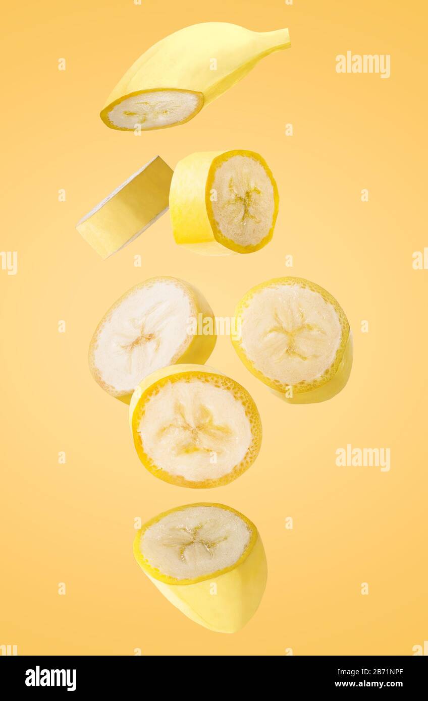 Falling banana fruits isolated on yellow background Stock Photo - Alamy