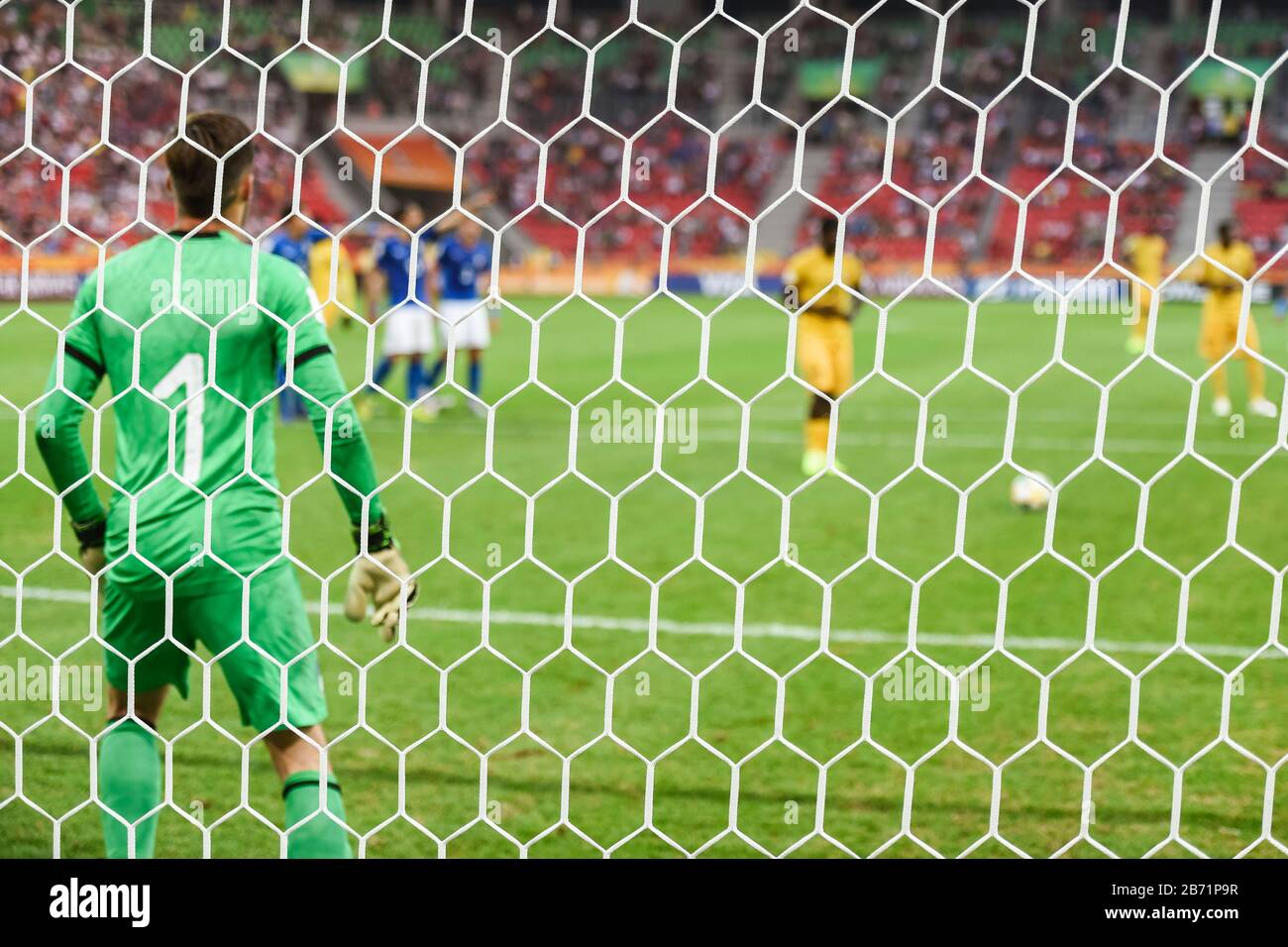 Net in soccer goal with goalkeeper and striker behind before penalty ...
