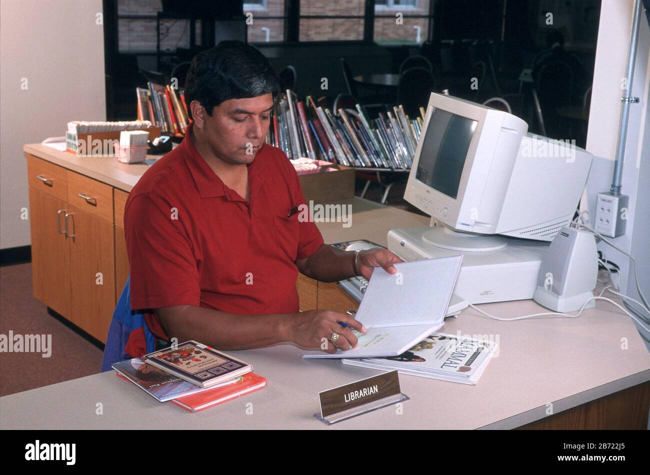 Austin, Texas USA: Male librarian working at his desk in elementary ...