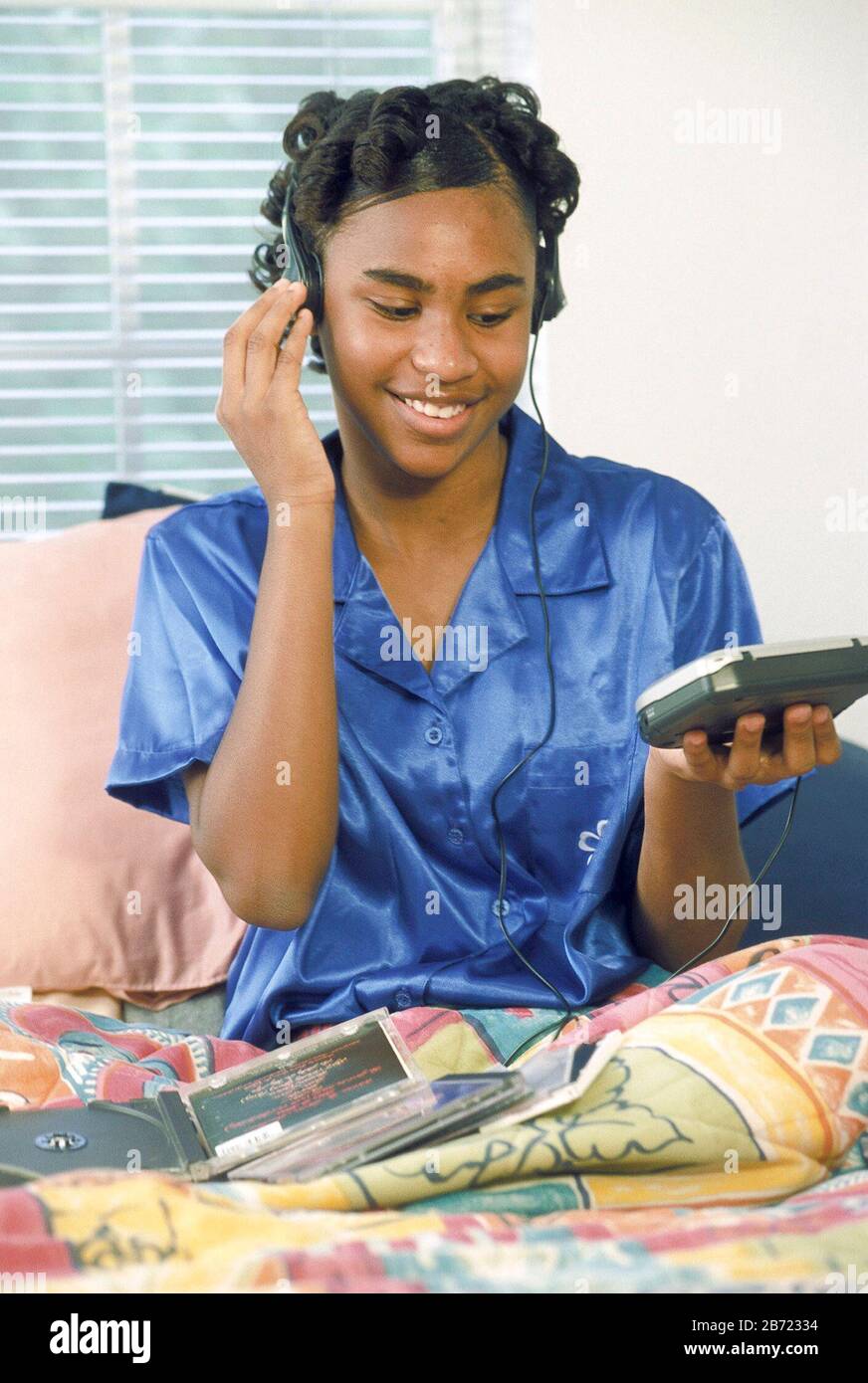 Austin Texas USA: 13-year-old Black teen girl uses headphones while ...