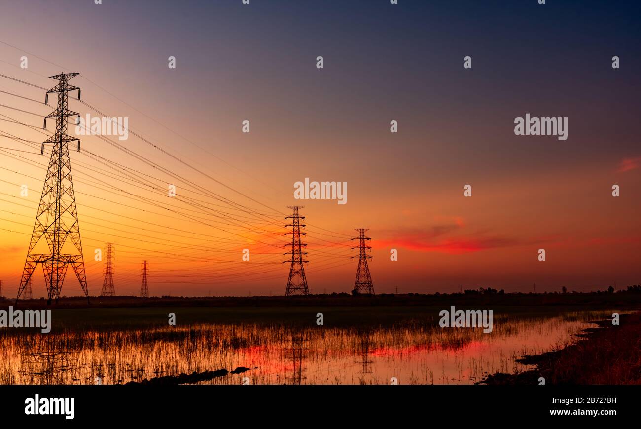 High voltage electric pylon and electrical wire with sunset sky ...