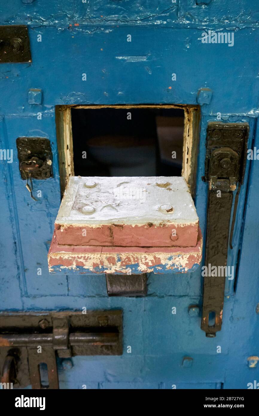 A fold down, pass through panel in a typical old, wood, painted cell ...