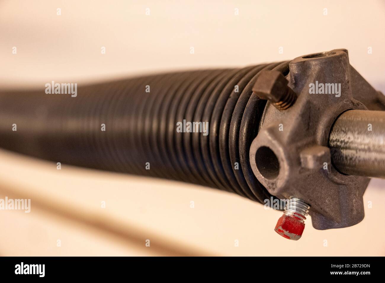 Close up side view of garage door coiled spring Stock Photo - Alamy