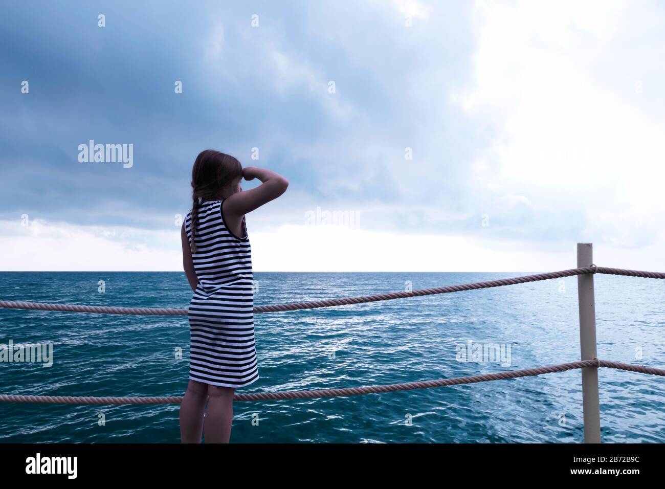 Beautiful little teenager girl standing on ship looking forward with ...