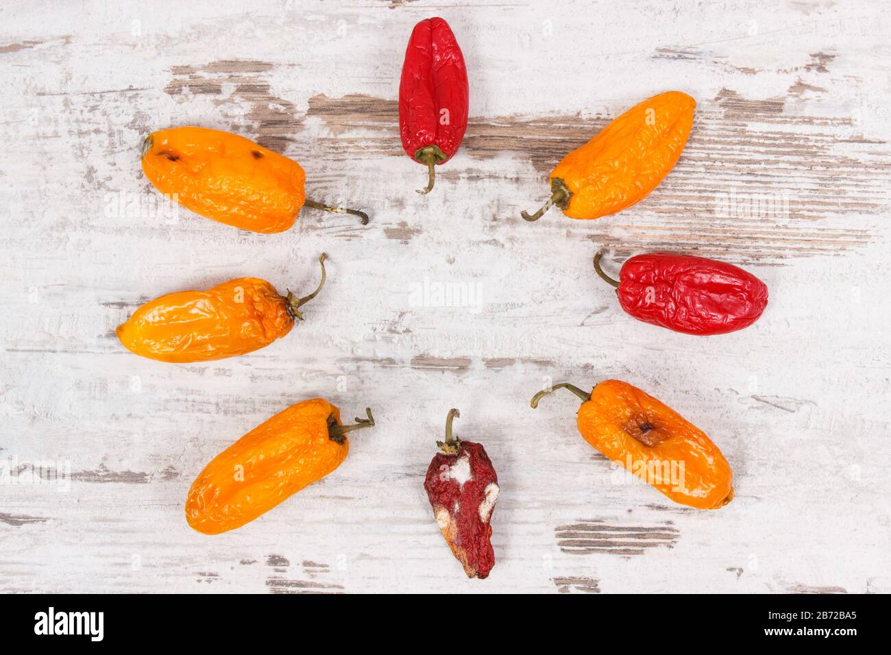 Old wrinkled moldy peppers on old rustic board, concept of unhealthy ...