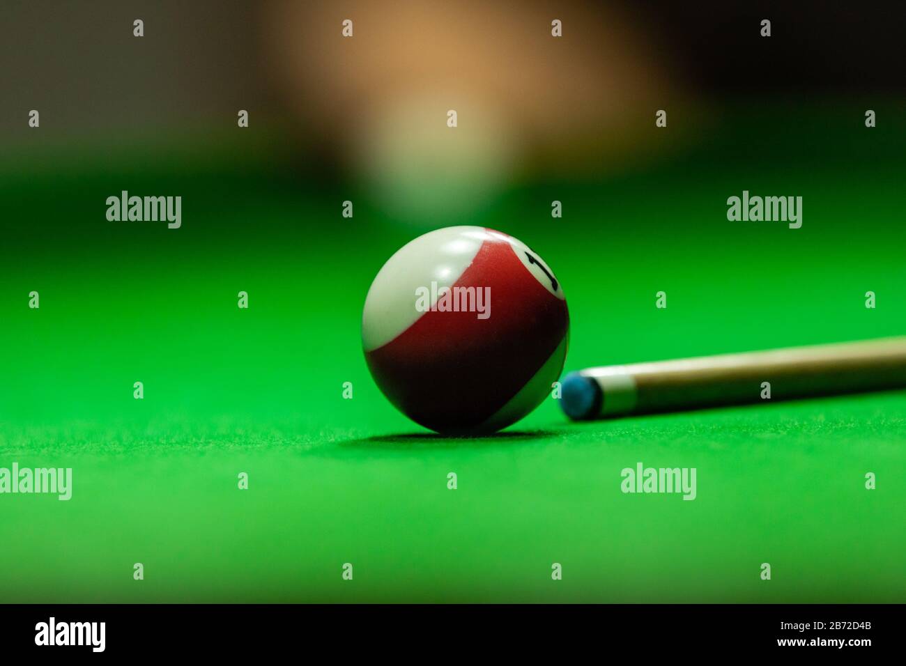 Pool table with stick and ball in a club house Stock Photo - Alamy