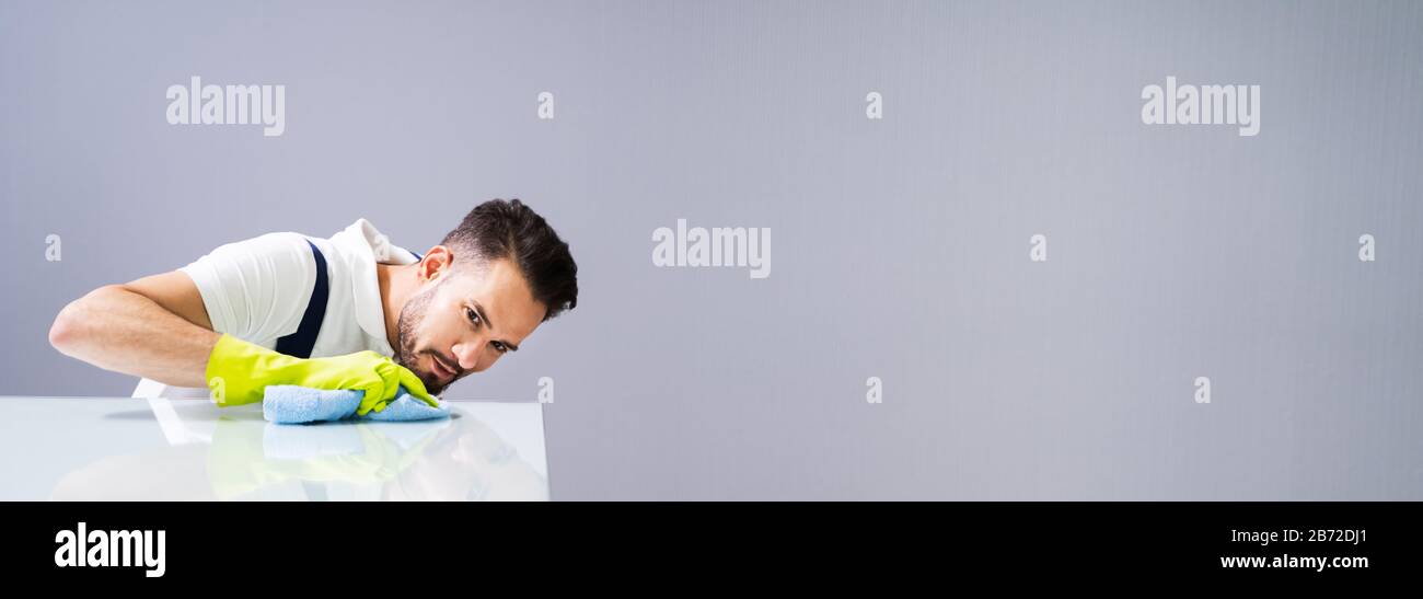 Worker Cleaning Computer Desk With Spray And Sponge Stock Photo - Alamy
