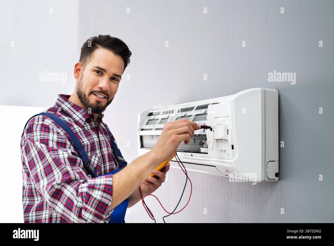 Portrait Of A Mid-adult Male Technician Testing Air Conditioner With ...