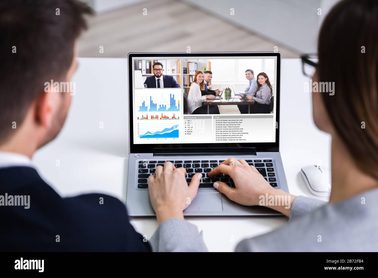Two Young Businesspeople Video Conferencing On Computer At Office Stock ...