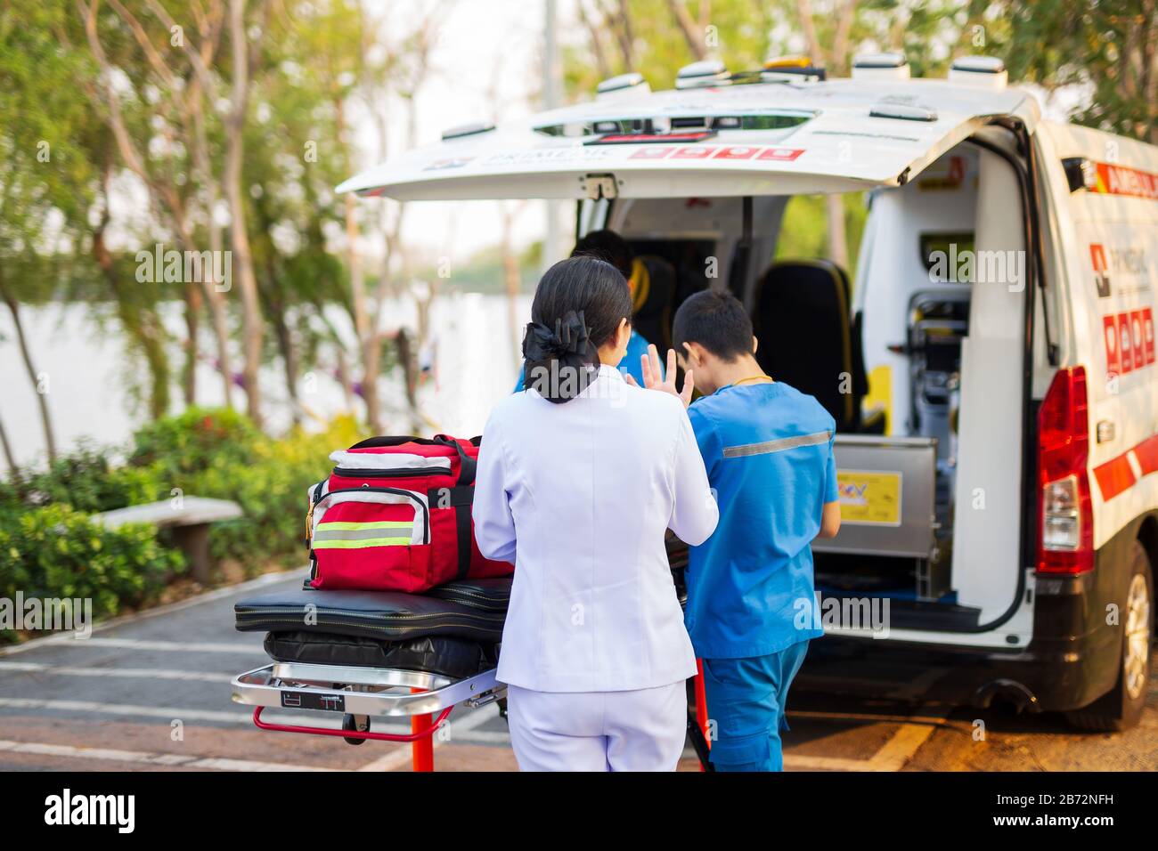 Emergency paramedic doctor and nurse standing in back of ambulance ...