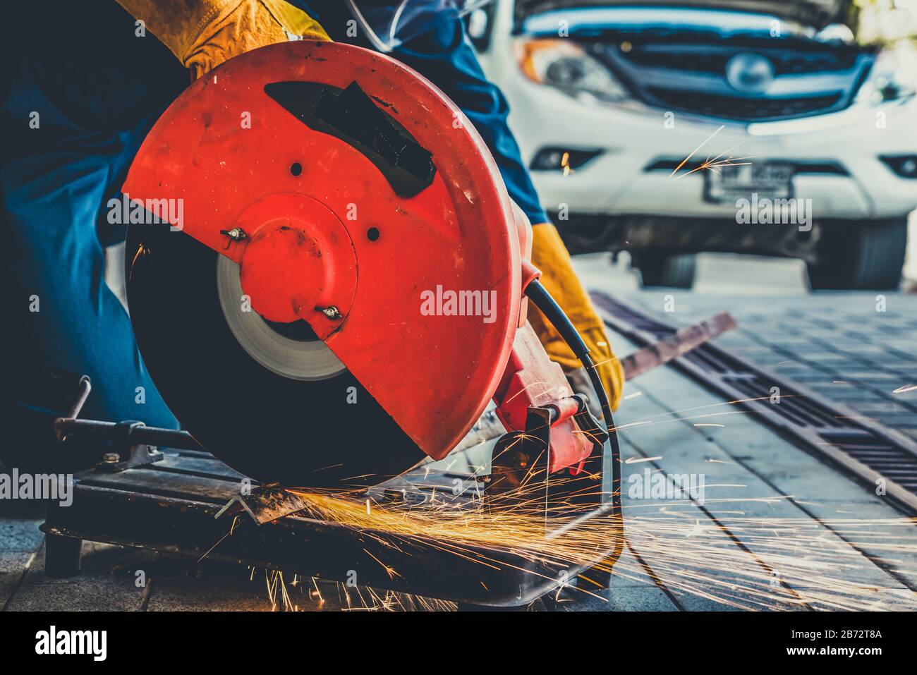 Professional mechanic is cutting steel metal with rotating diamond ...