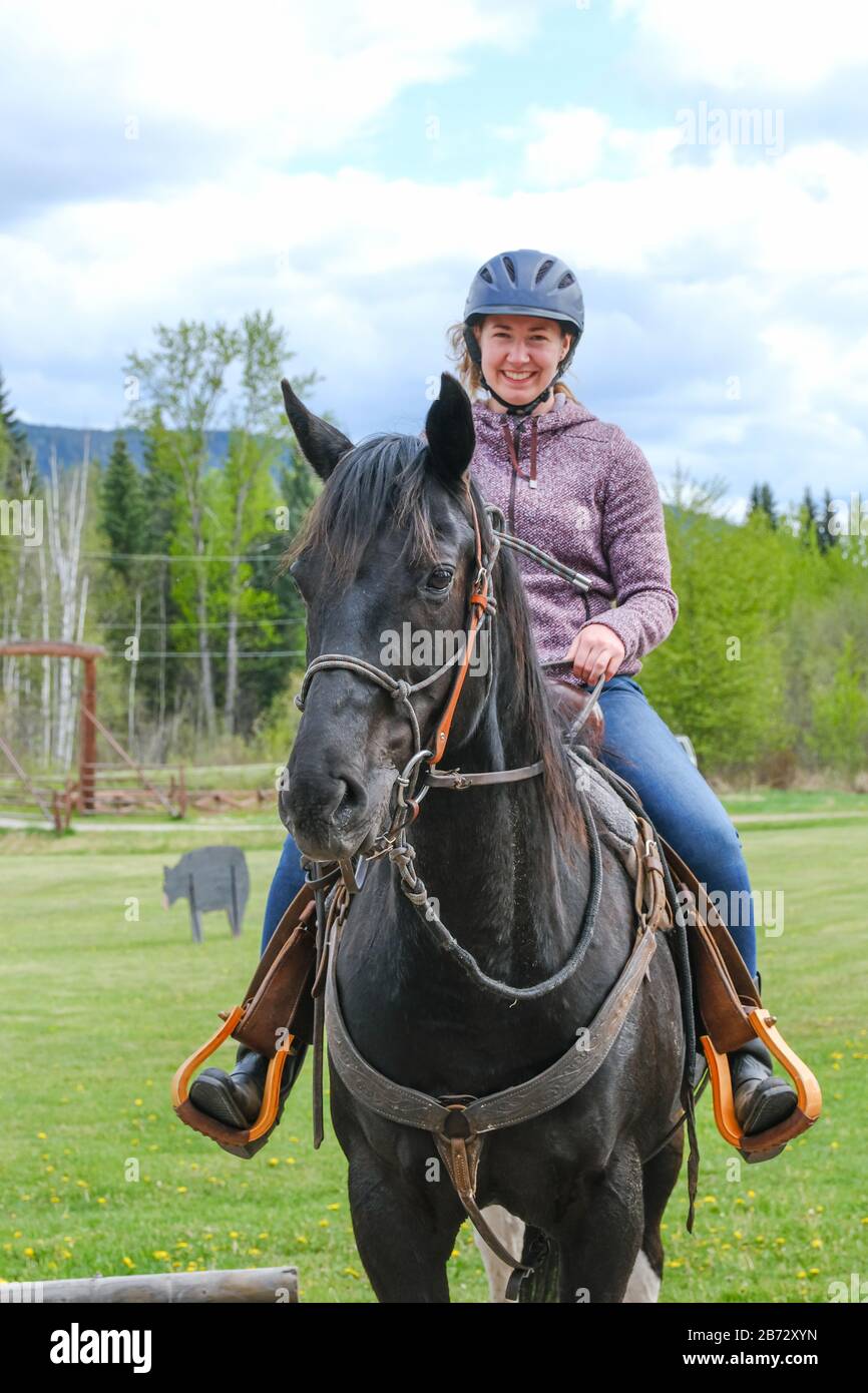 A young woman riding a horse, part of horse, front view in Banff ...