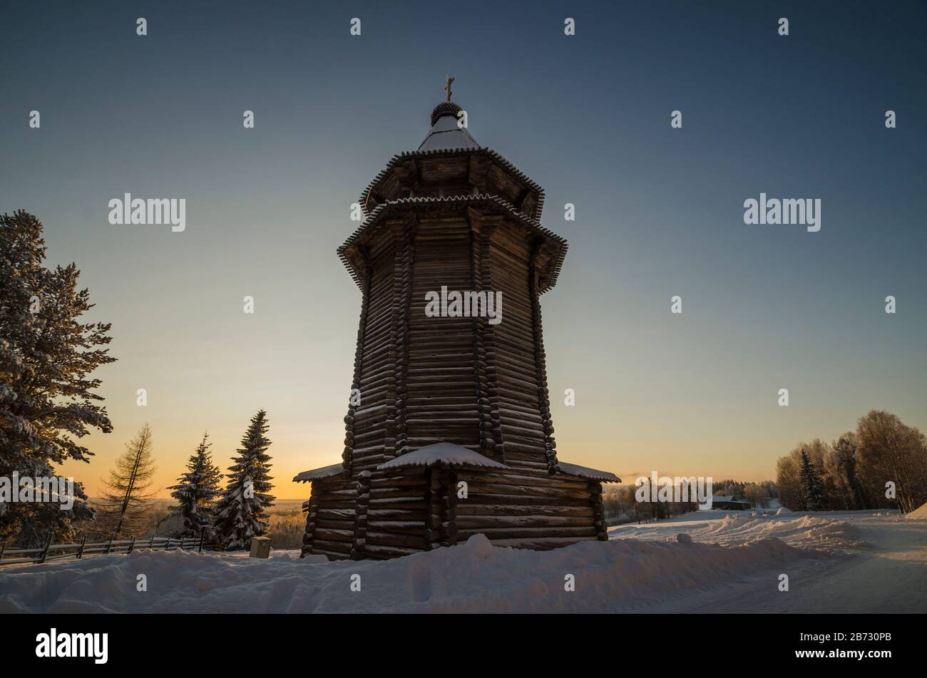 Beautiful wooden bell tower on a sunset background. Road to the tower ...