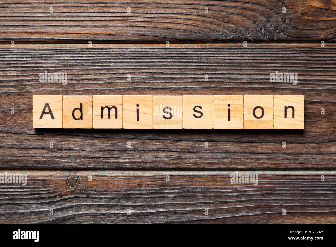 ADMISSION word written on wood block. ADMISSION text on wooden table ...