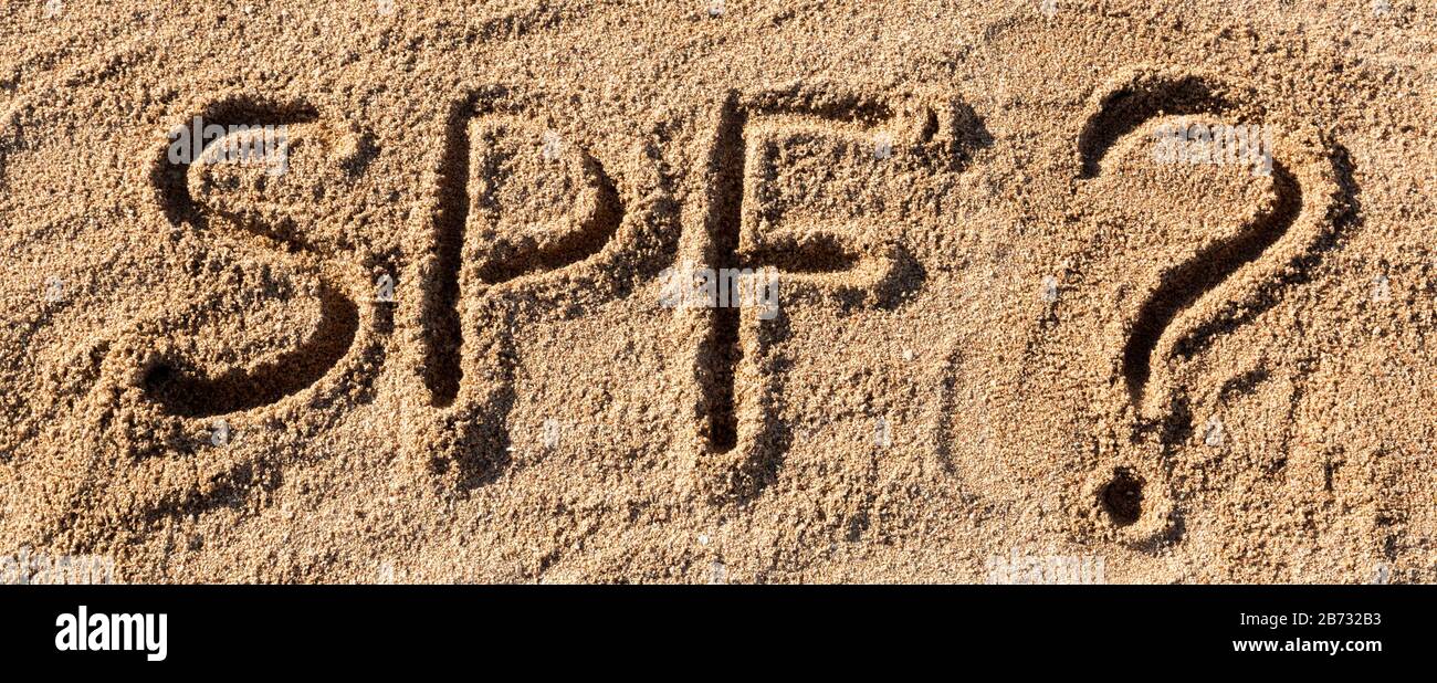 Sun protect factor concept. SPF word written on the beach with question ...
