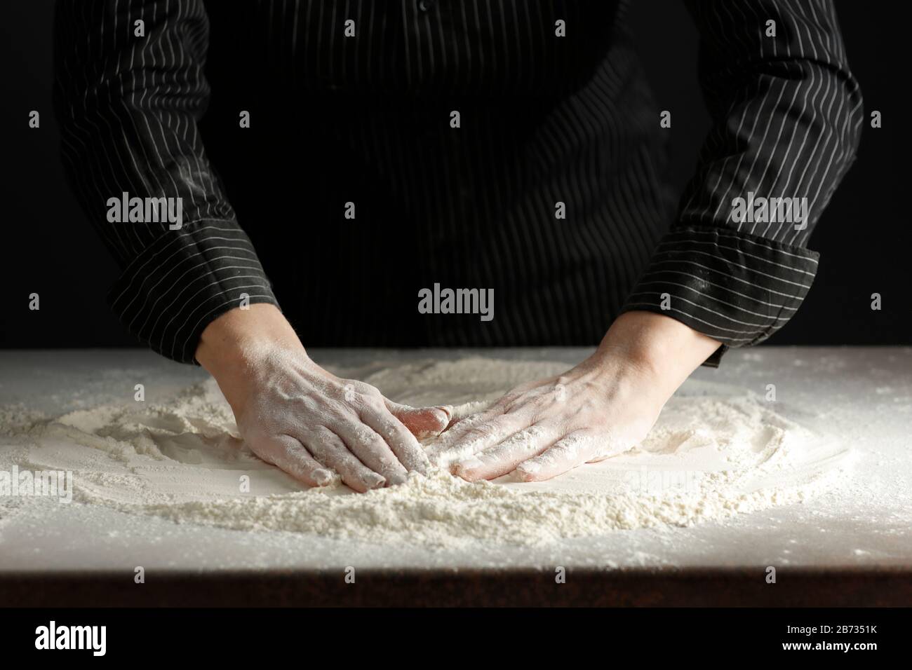 Flour on a kitchen table with a black moody background in the morning ...