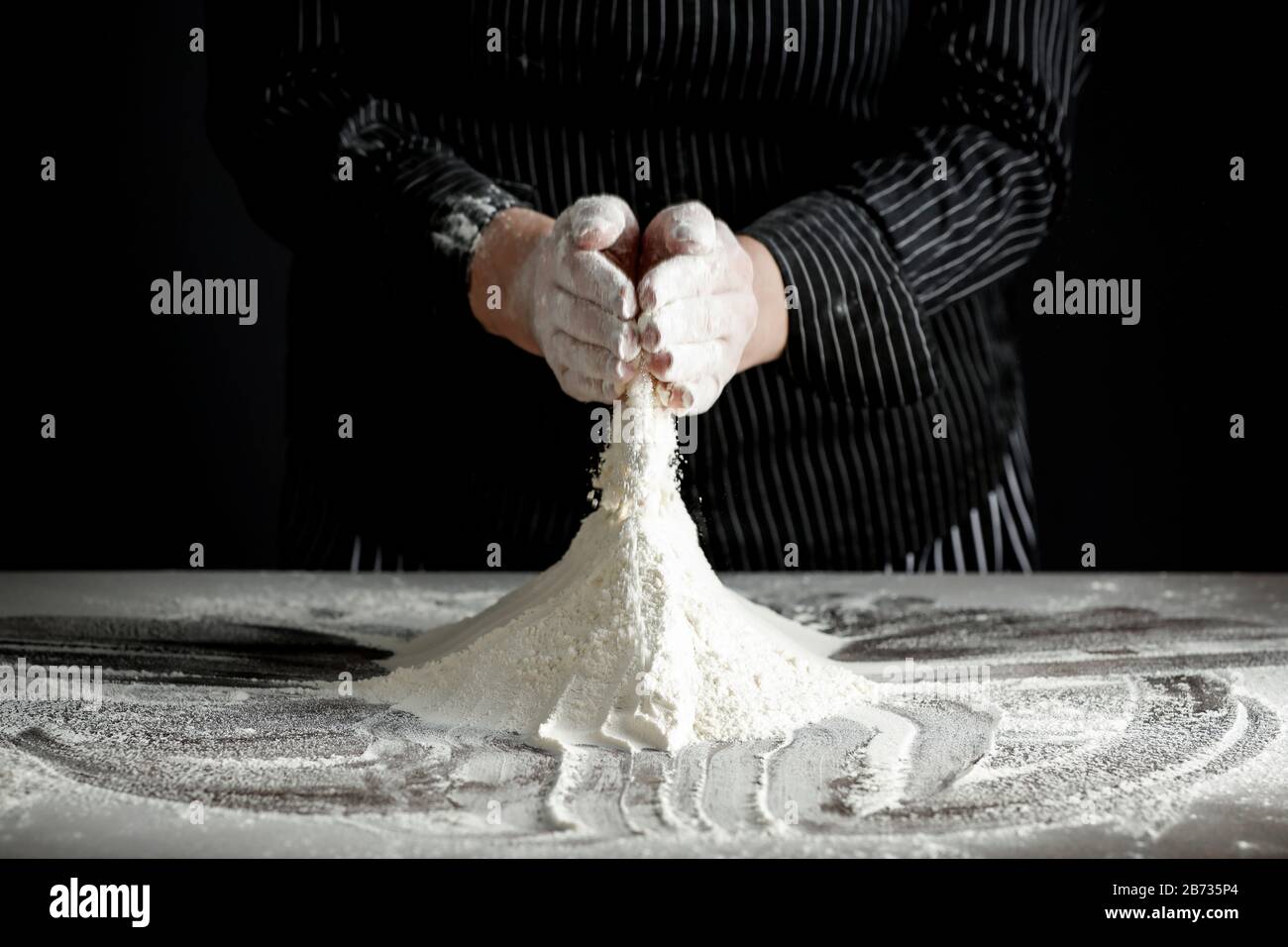 Flour on a kitchen table with a black moody background in the morning ...
