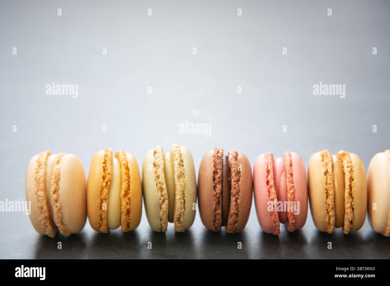 Row of french colorful macaroons over dark, black background with copy ...