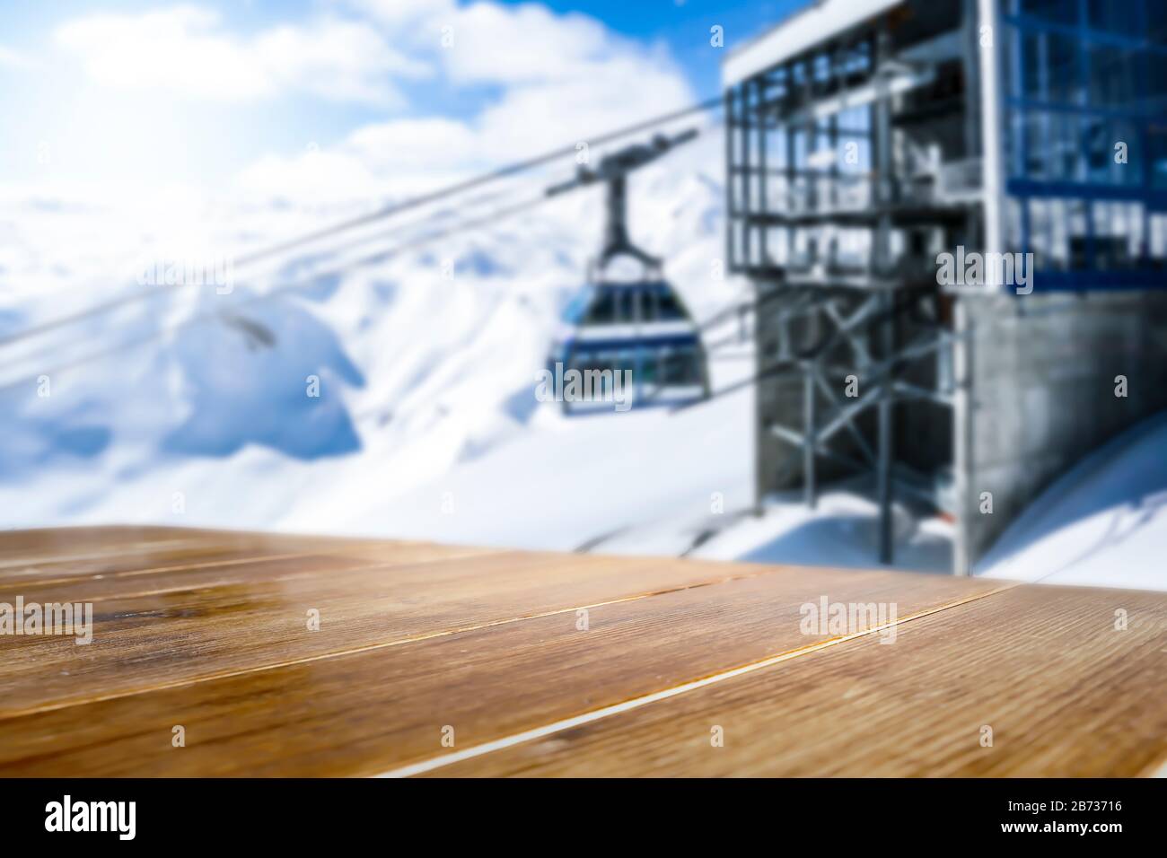 Wooden Table top and high mountain view in winter. Ski routes in the ...