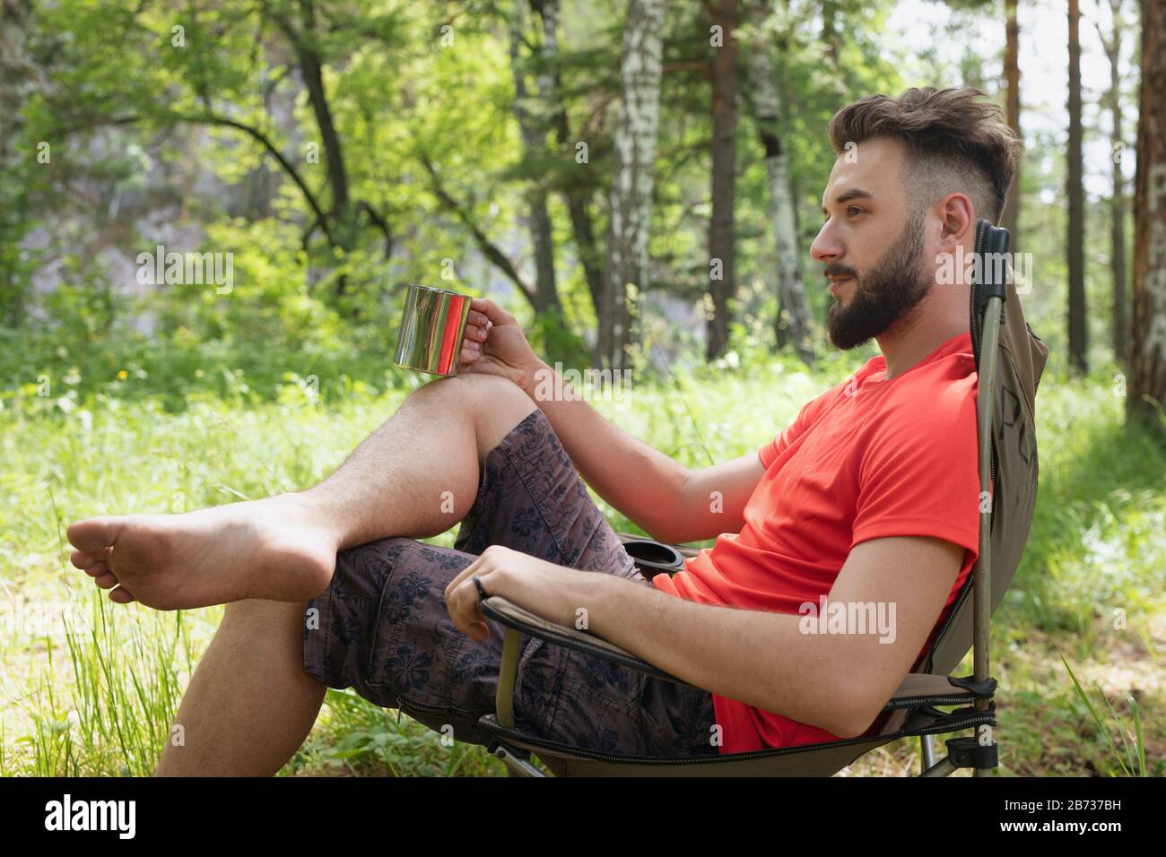 Tourist man in forest at campsite on nature in summer. Travel ...