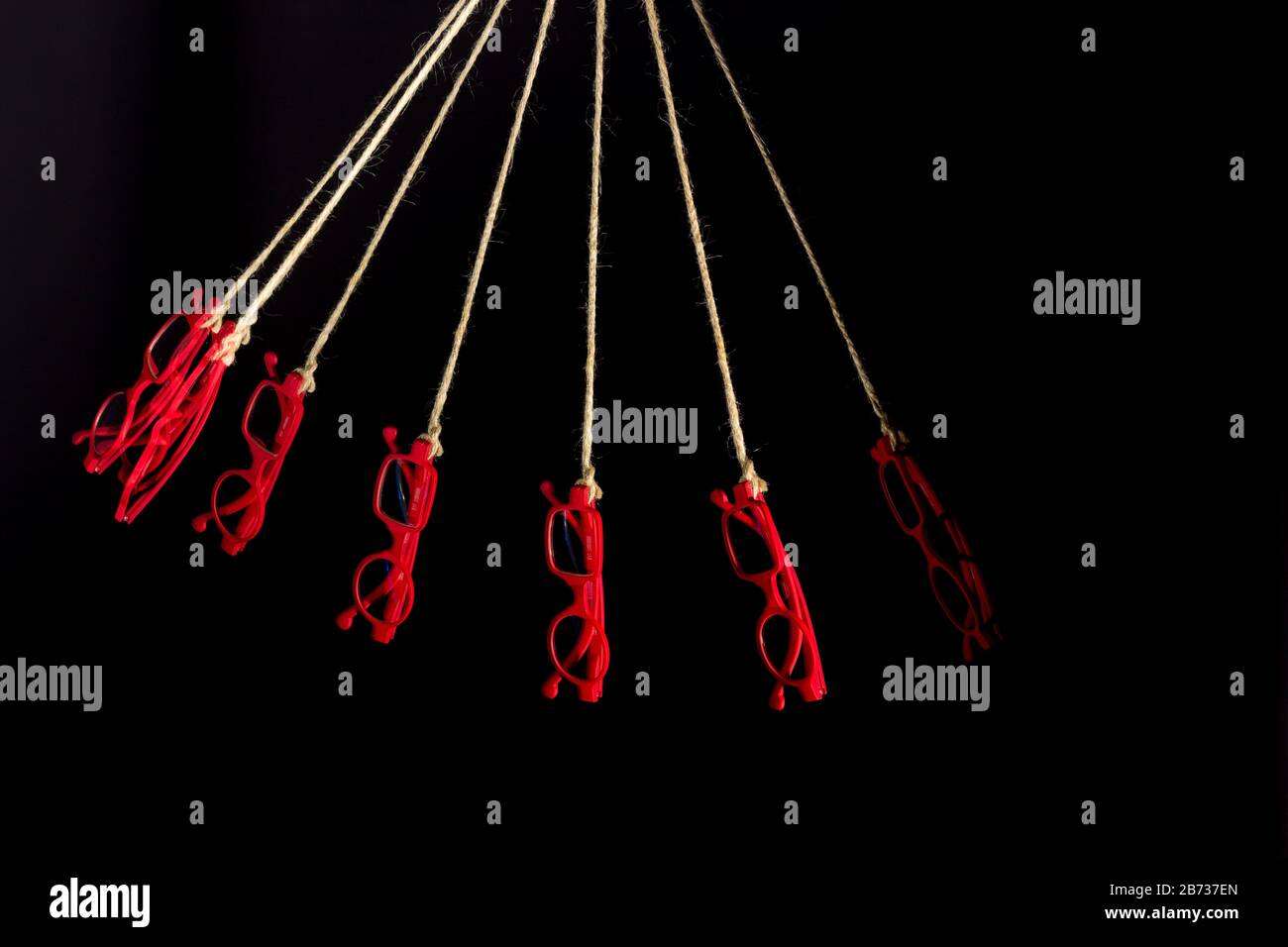 Glasses hanging on a string, several images of the same glasses that ...