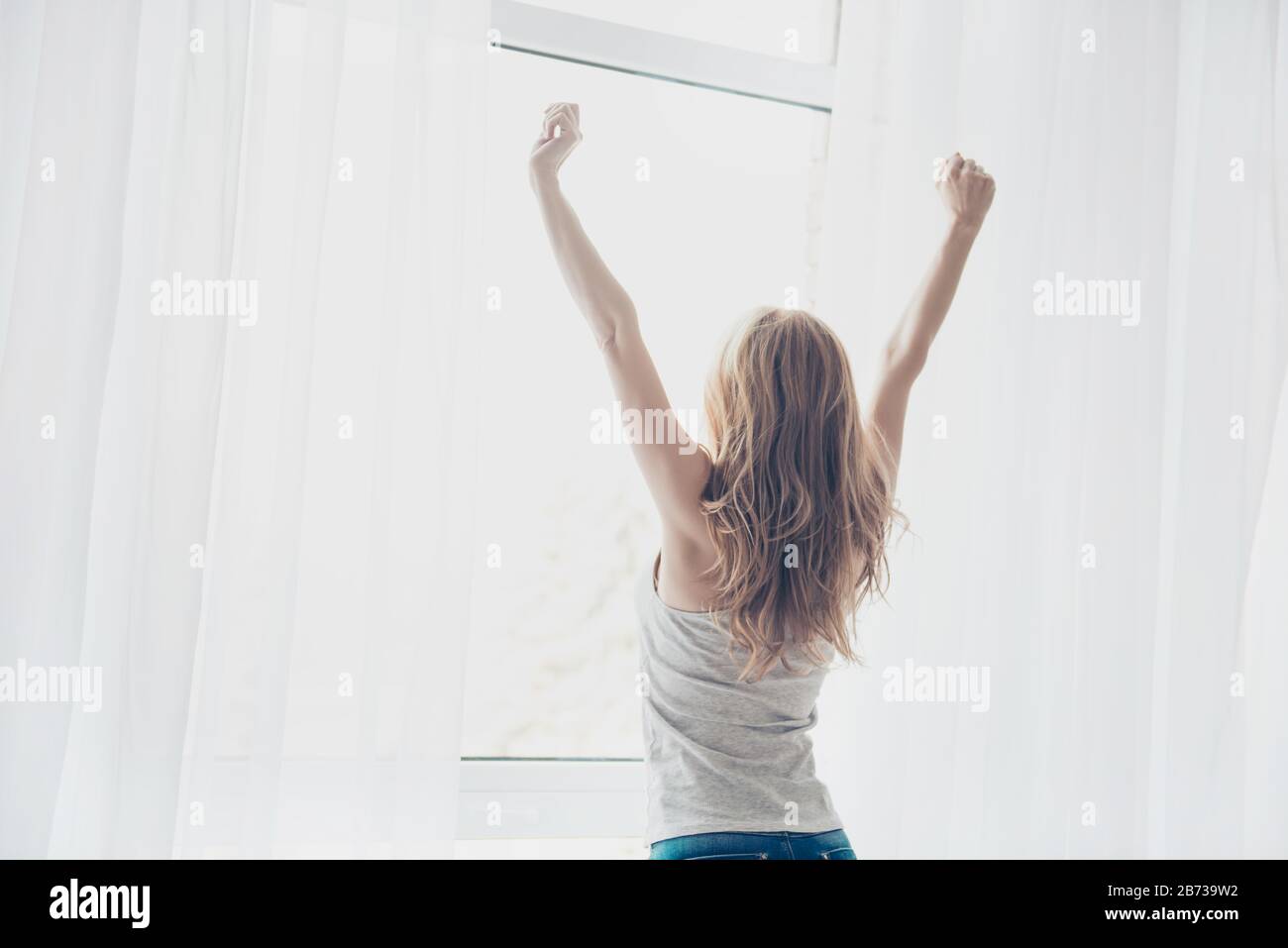 Good morning! Back view photo of happy cute young woman with long hair ...