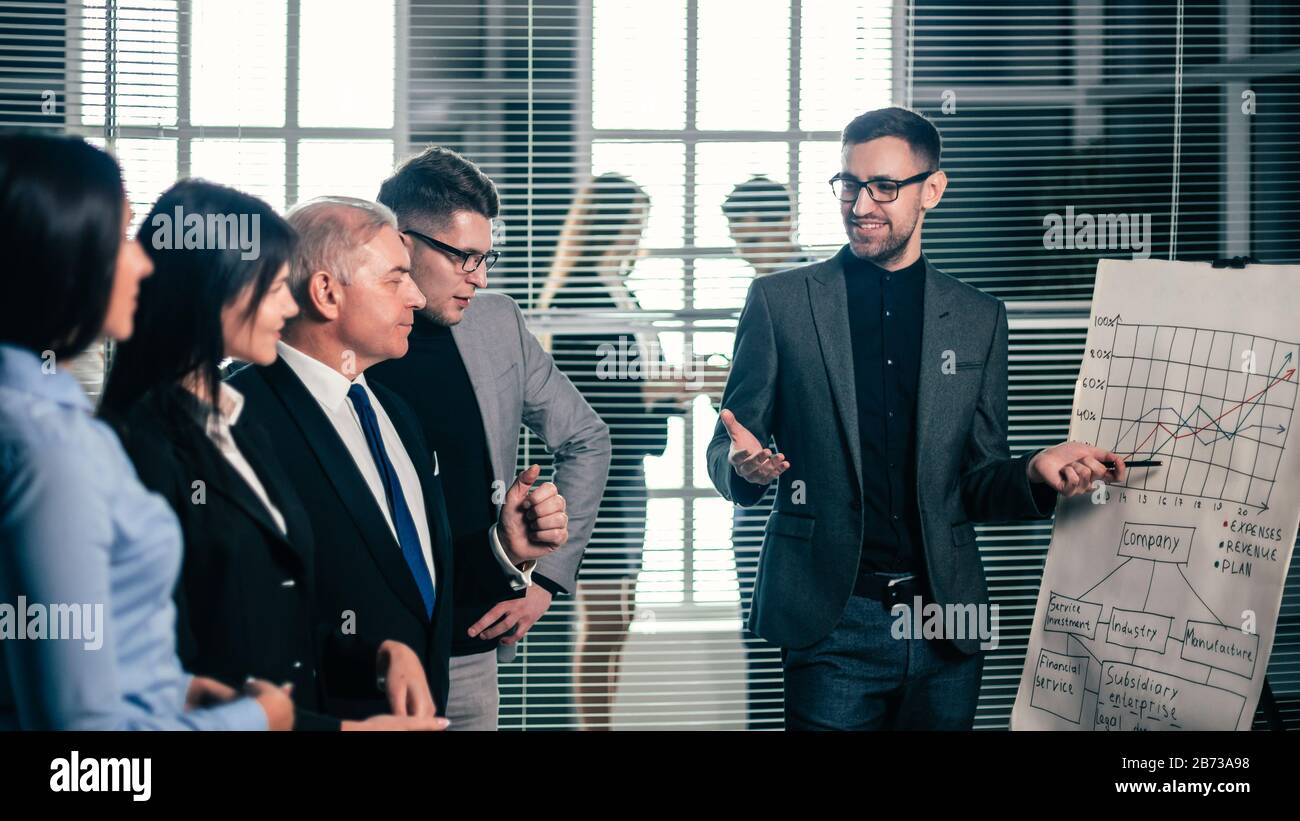 project Manager pointing to a flipchart with a schedule Stock Photo - Alamy