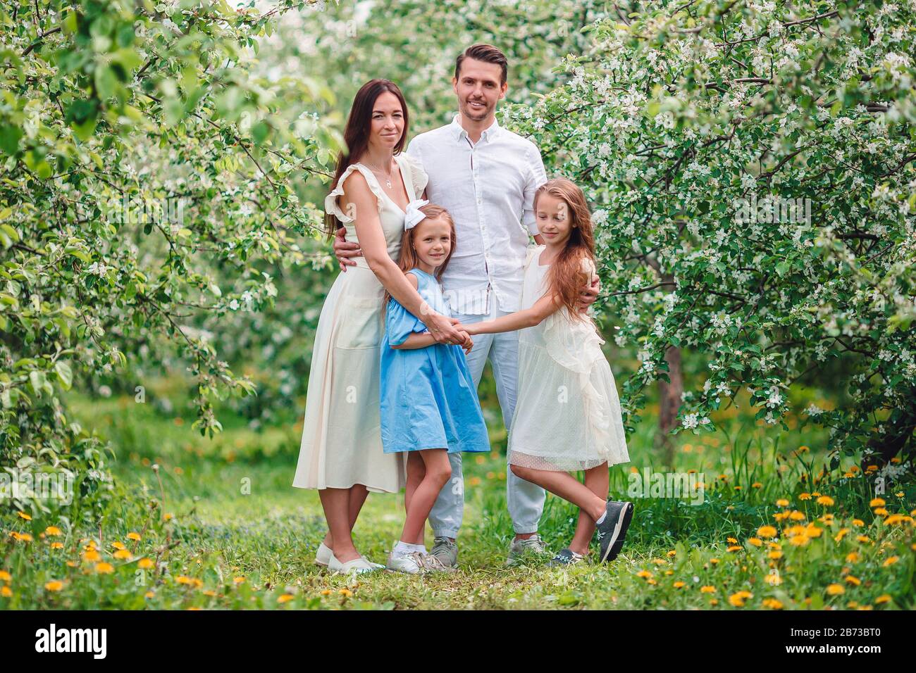 Adorable family in blooming cherry garden on beautiful spring day Stock ...