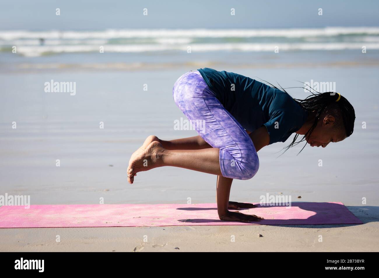 Side view of woman doing a yoga position at the beach Stock Photo - Alamy