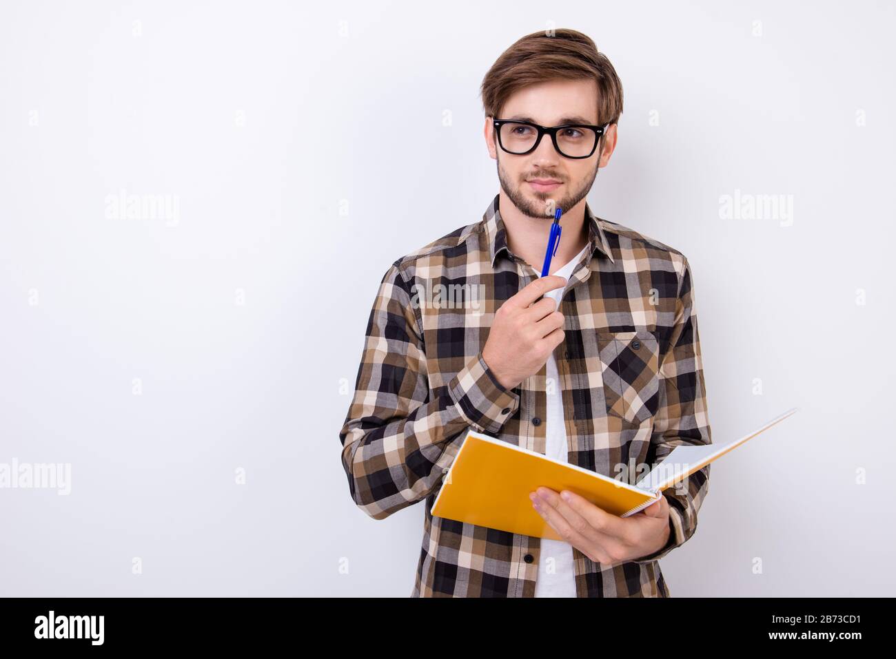 Smart smiling handsome student with great idea holding notebook Stock ...
