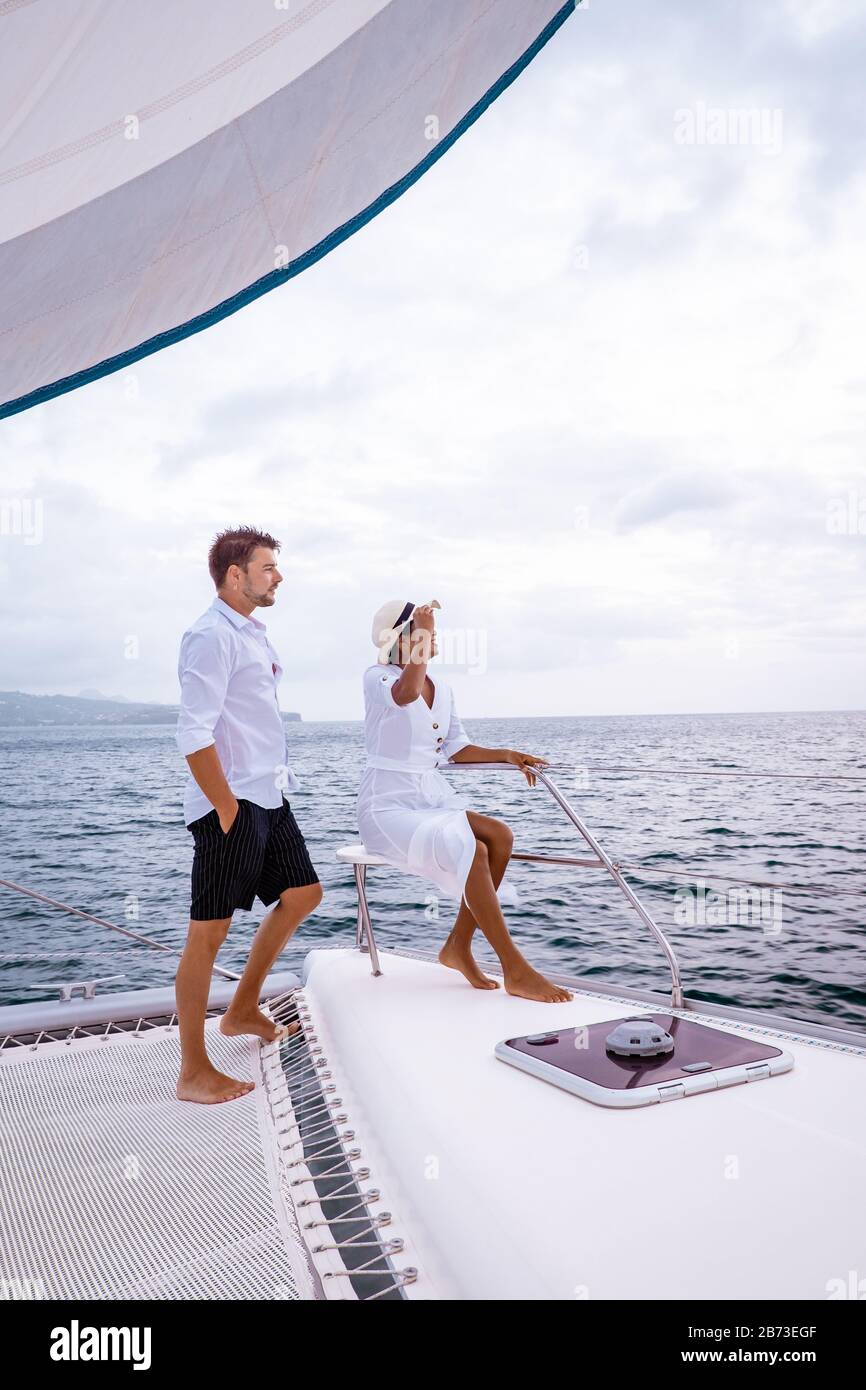 St Lucia, couple men and woman watching sunset from sailing boat in the ...