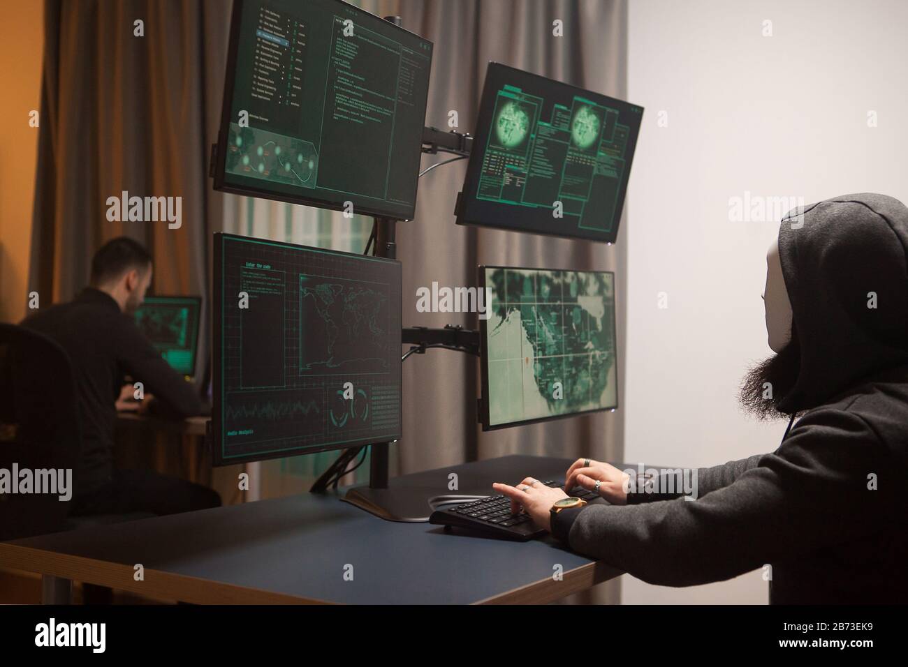 Masked and dangerous hacker in front of computer. Vulnerable government Stock Photo - Alamy