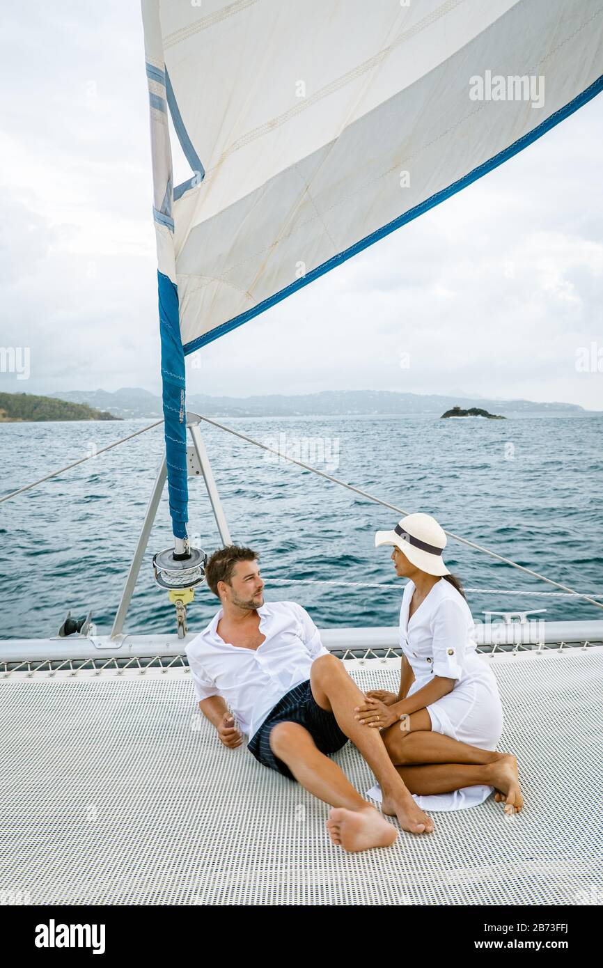St Lucia, couple men and woman watching sunset from sailing boat in the ...