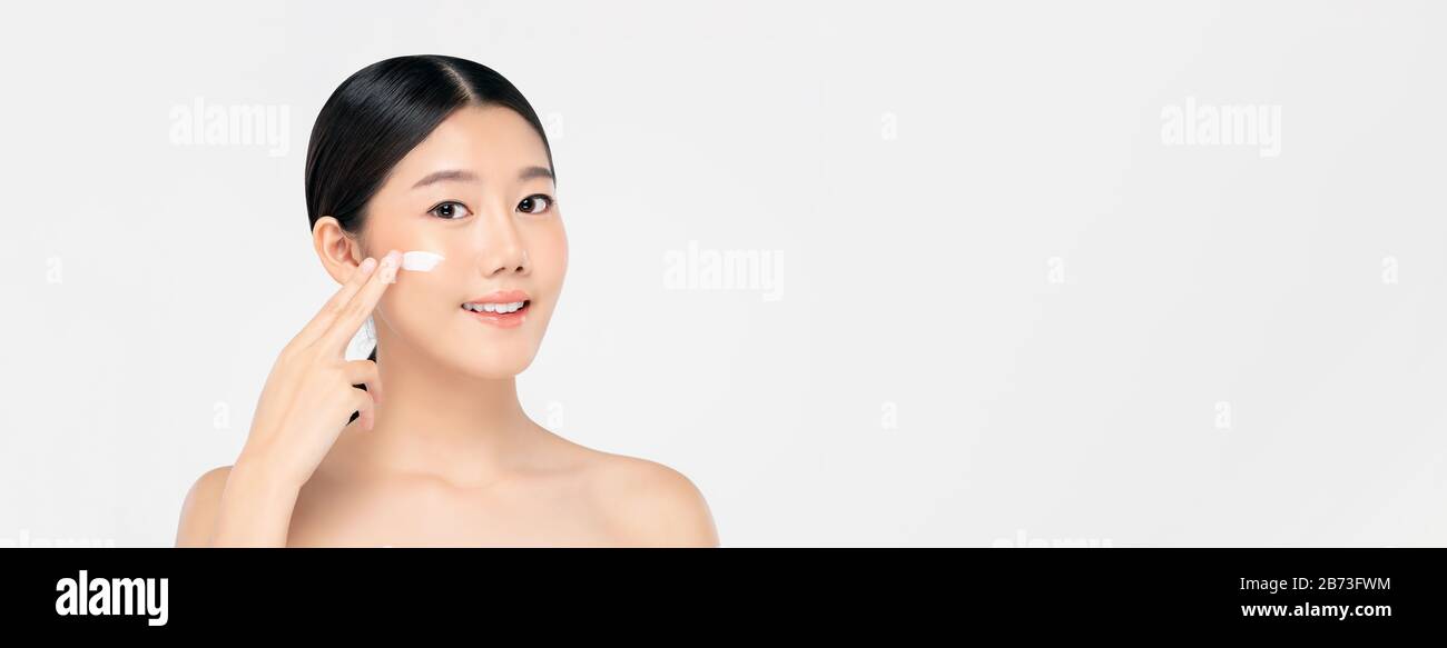 Young beautiful Asian woman with fresh clean appearance applying cream ...