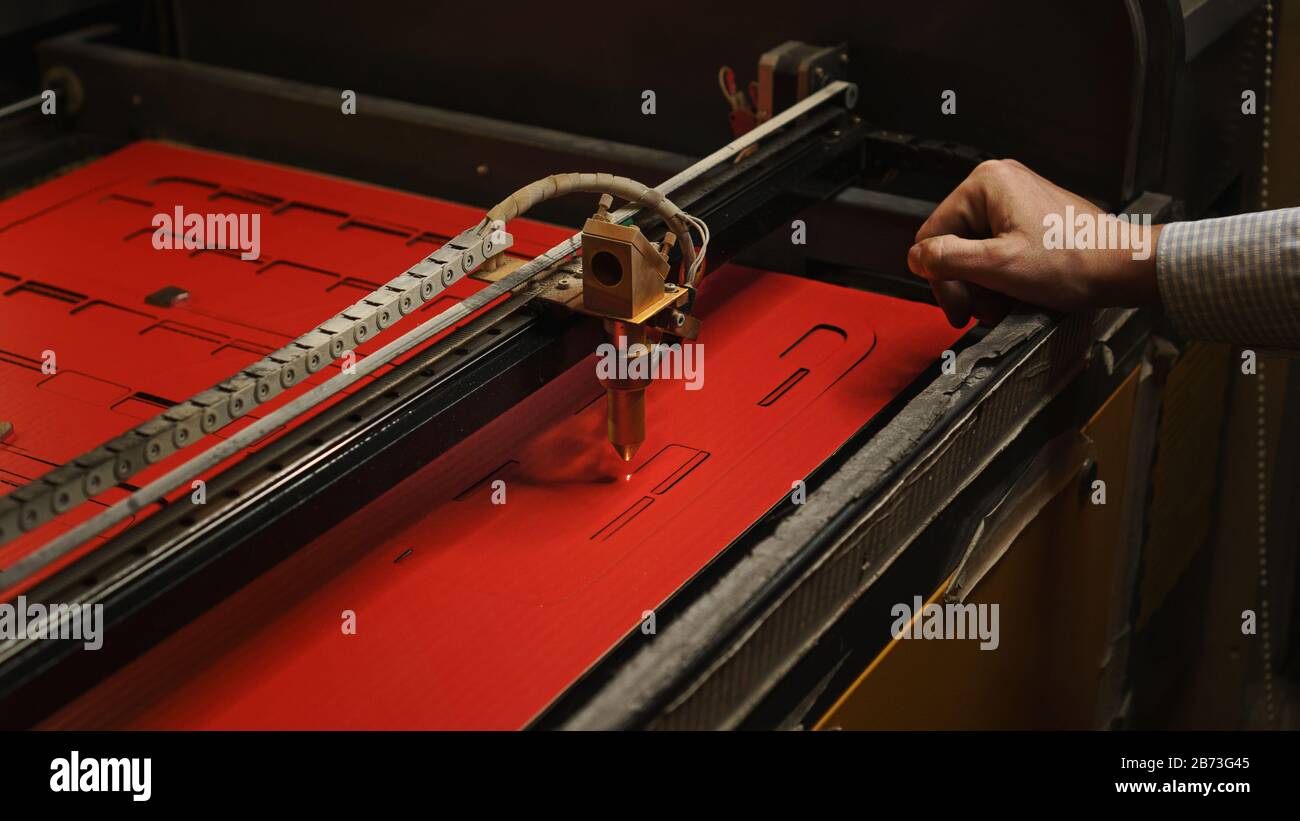 Laser cutting beam high precision on a paperboard. Modern machine ...