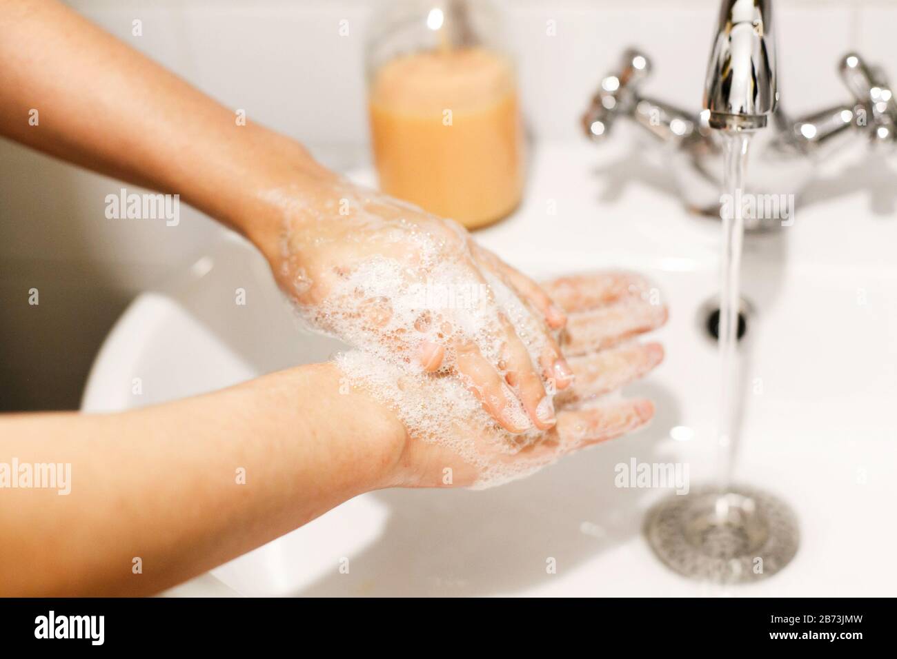 Washing hands. Hands washing with soap foam on background of water ...