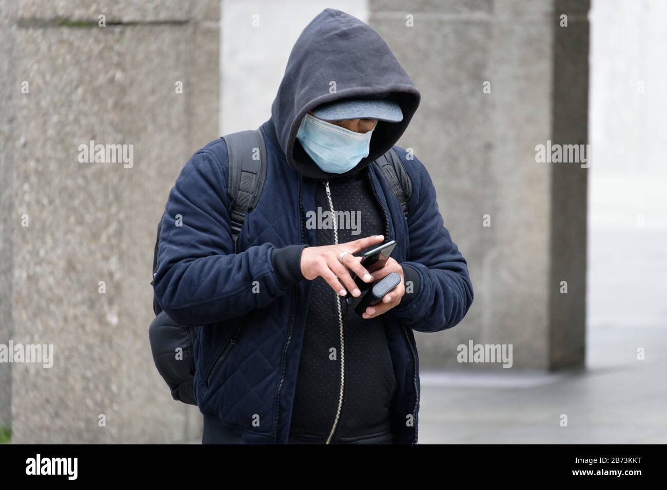 Cologne, Germany. 13th Mar, 2020. A man downtown is wearing a mask ...