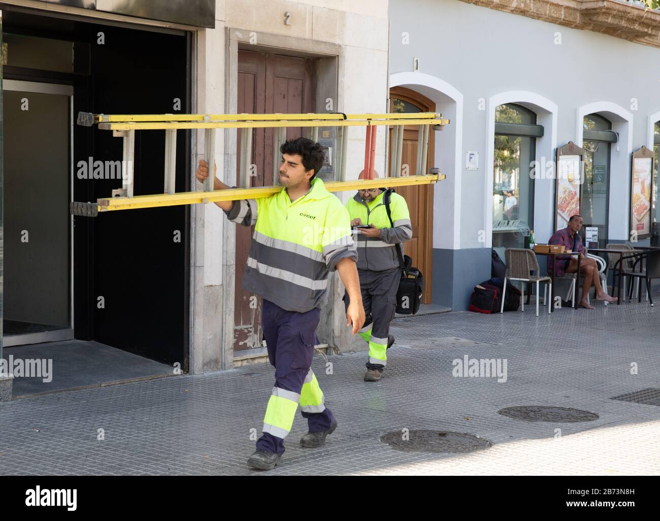 Man walking outdoors two ladders hi-res stock photography and images ...
