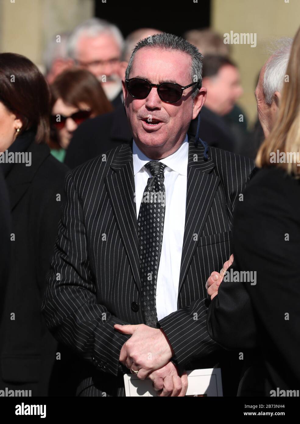 Former boxer Dave 'Boy' McAuley leaves the church following the funeral ...