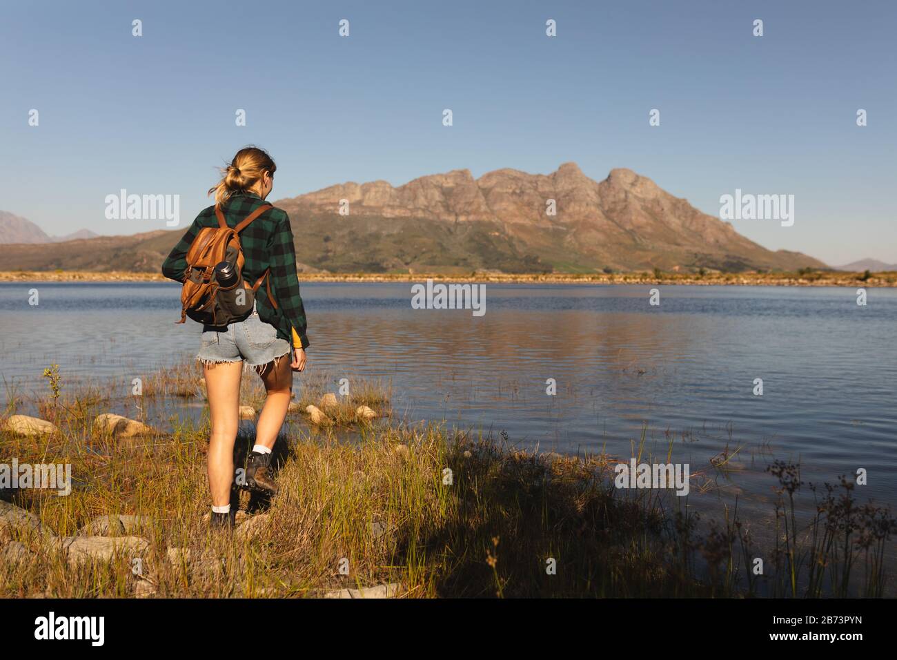 Rear view of woman walking through the lake Stock Photo - Alamy