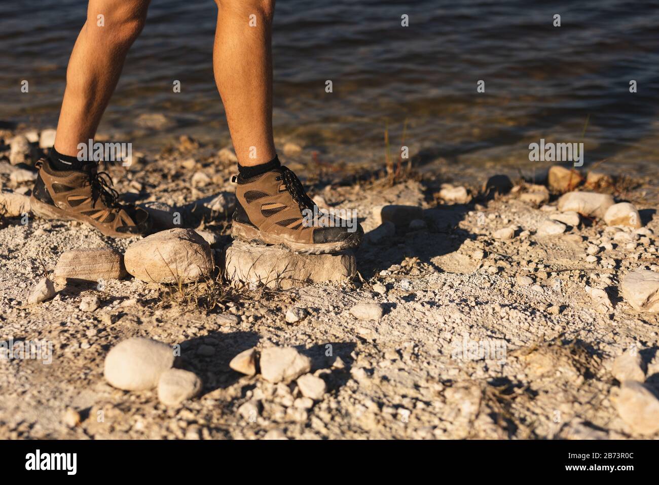 Side view of man walking next to the lake Stock Photo - Alamy