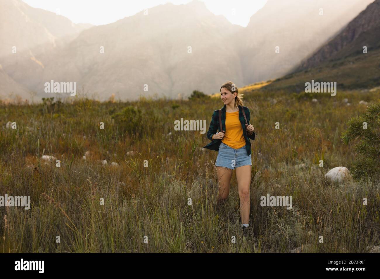 Front view of woman with backpack walking outside Stock Photo - Alamy