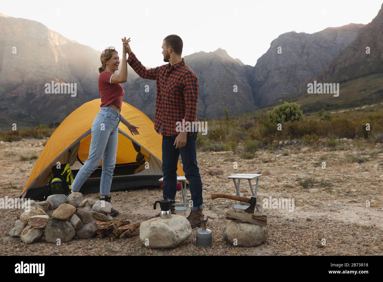 Side view of couple doing a high five outside Stock Photo - Alamy